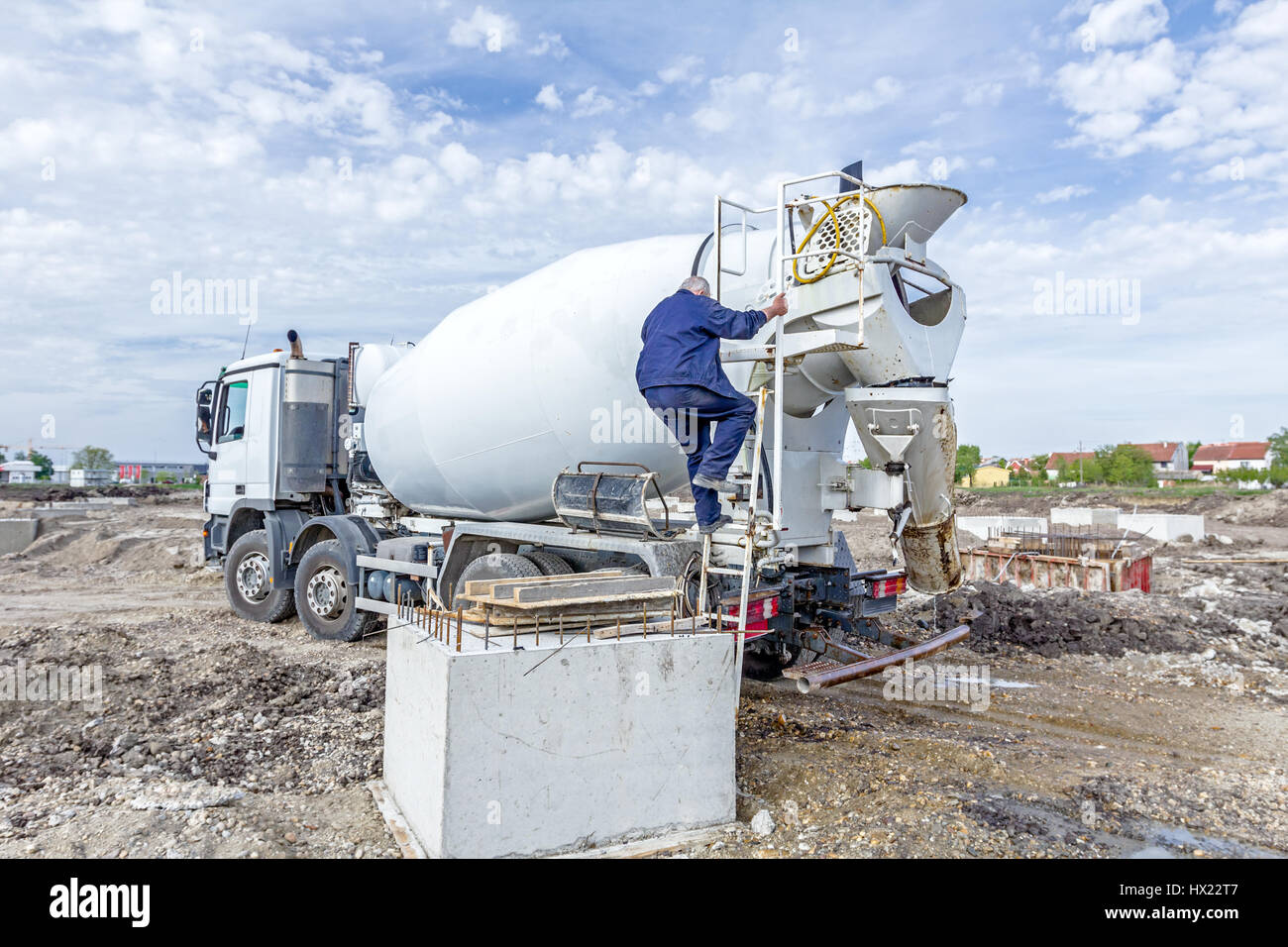 Driver is washing mixer truck with water jet, after concrete casting ...