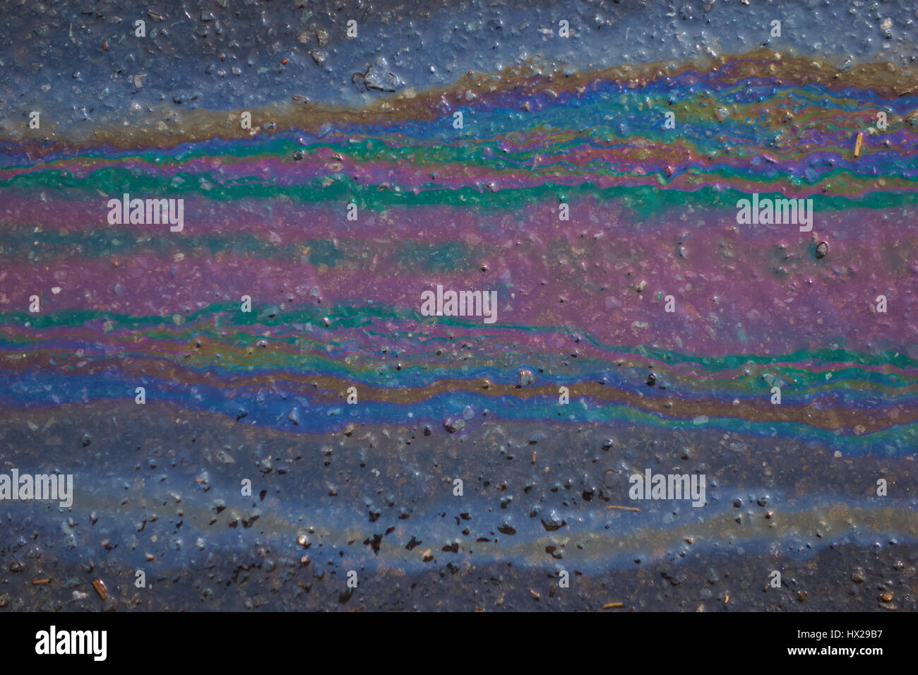 Oil fom car spilled on wet road Stock Photo - Alamy