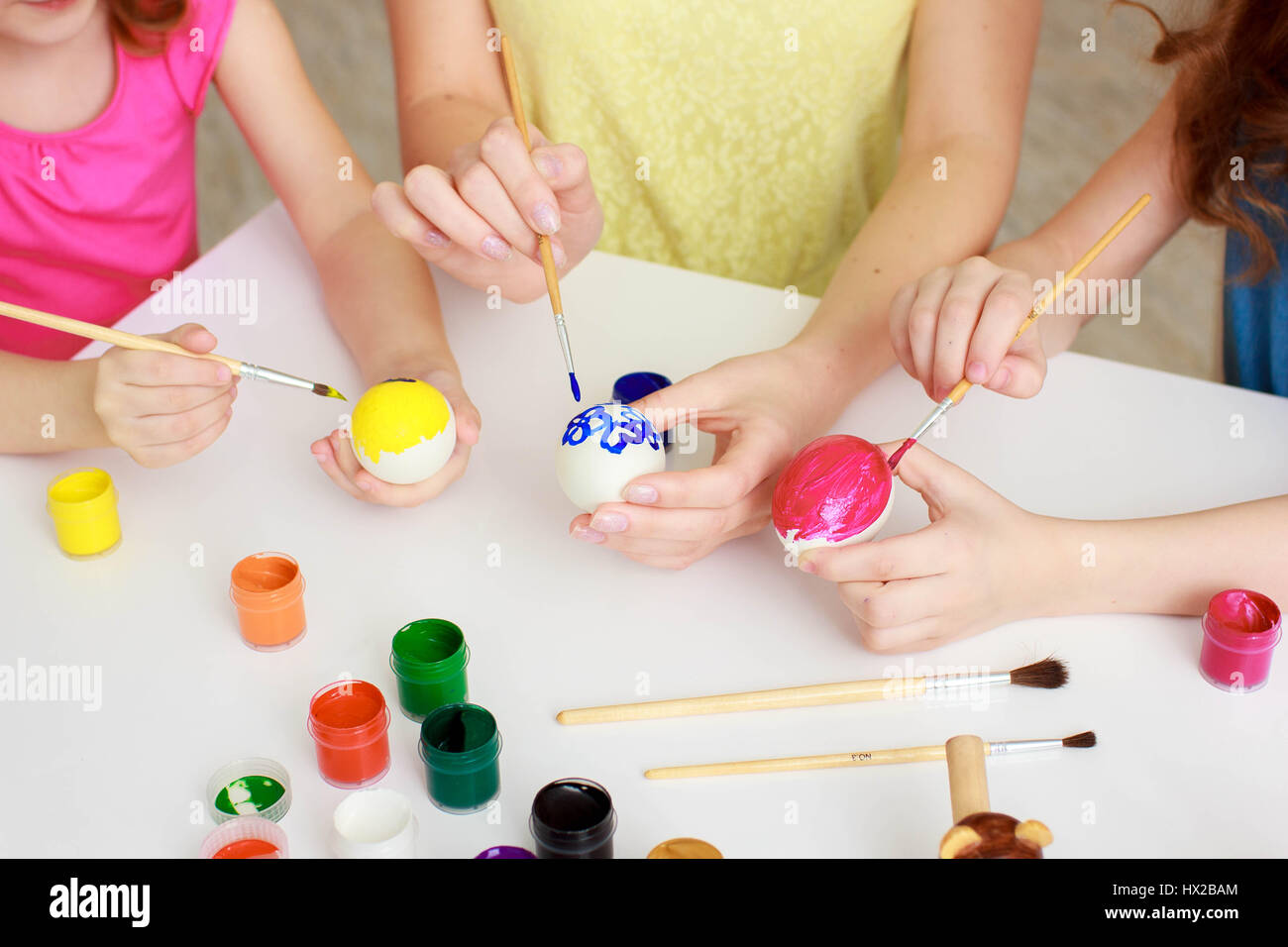 Happy easter A mother, and daughters painting Easter eggs. Happy family ...