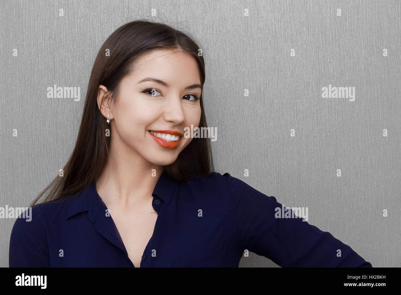 Portrait of a beautiful young business woman standing against grey ... Portrait of a beautiful young business woman standing against grey ...