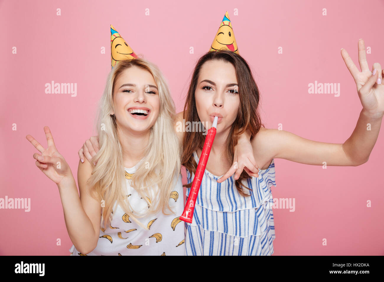 Two smiling pretty young women celebrating birthday and having fun over ...