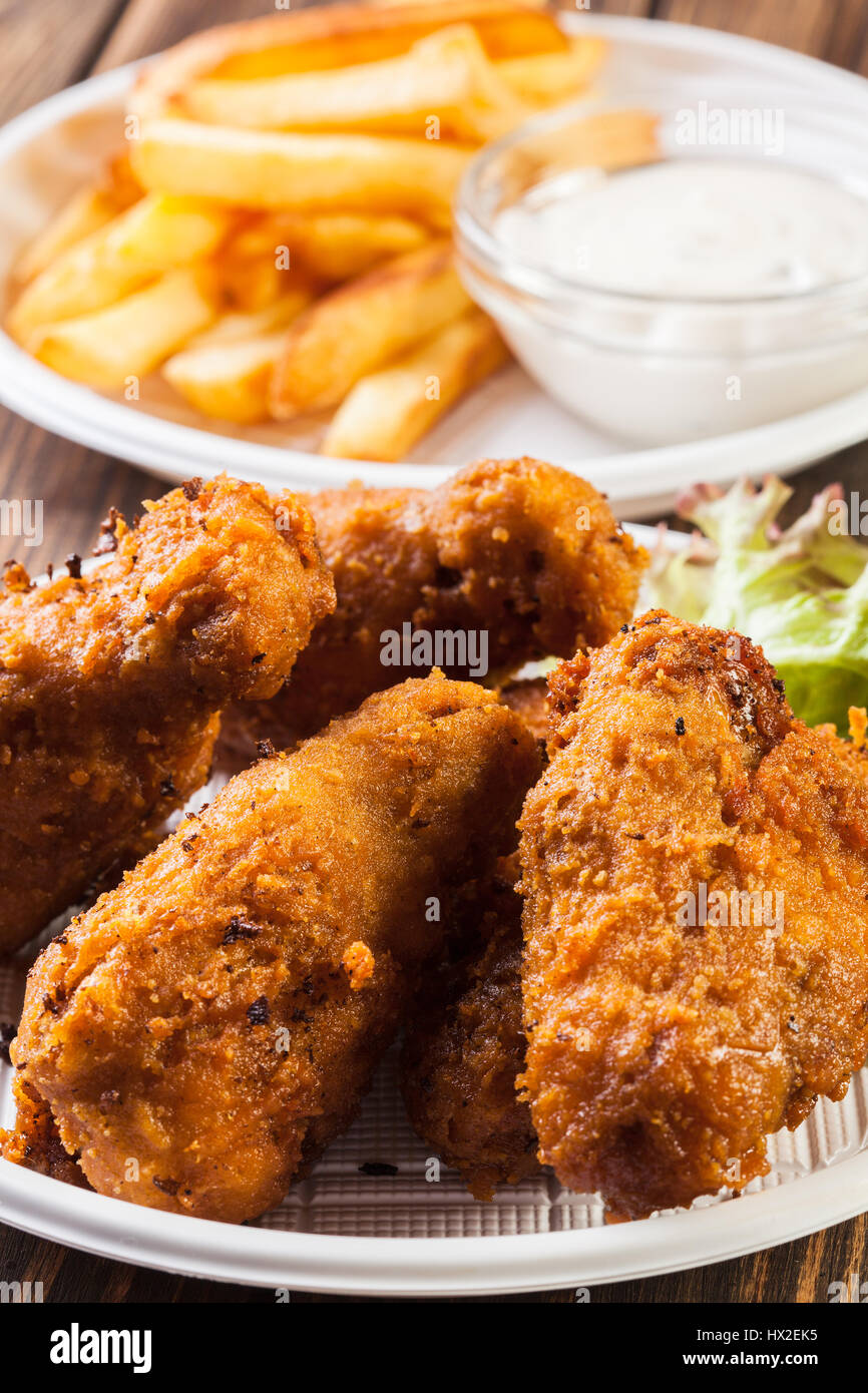 Crisp crunchy golden chicken wings with chips Stock Photo - Alamy