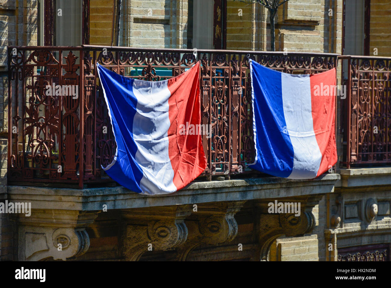 French Tricolore flags suspended from an iron railing balcony Stock ...