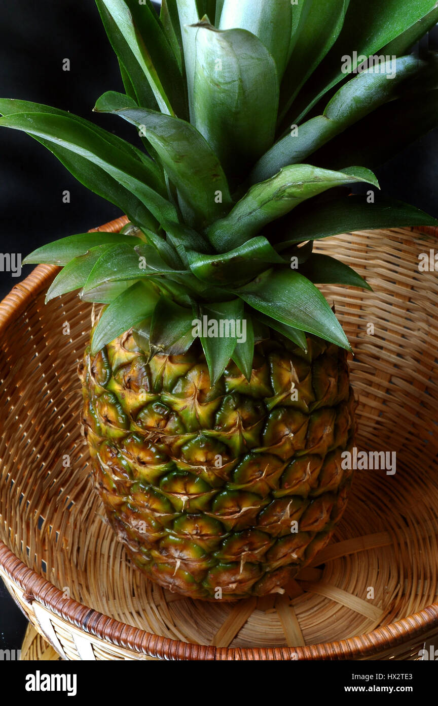 pineapple in wicker basket Stock Photo - Alamy