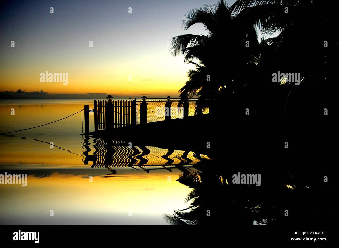 sunset over ocean with dock reflection Stock Photo - Alamy