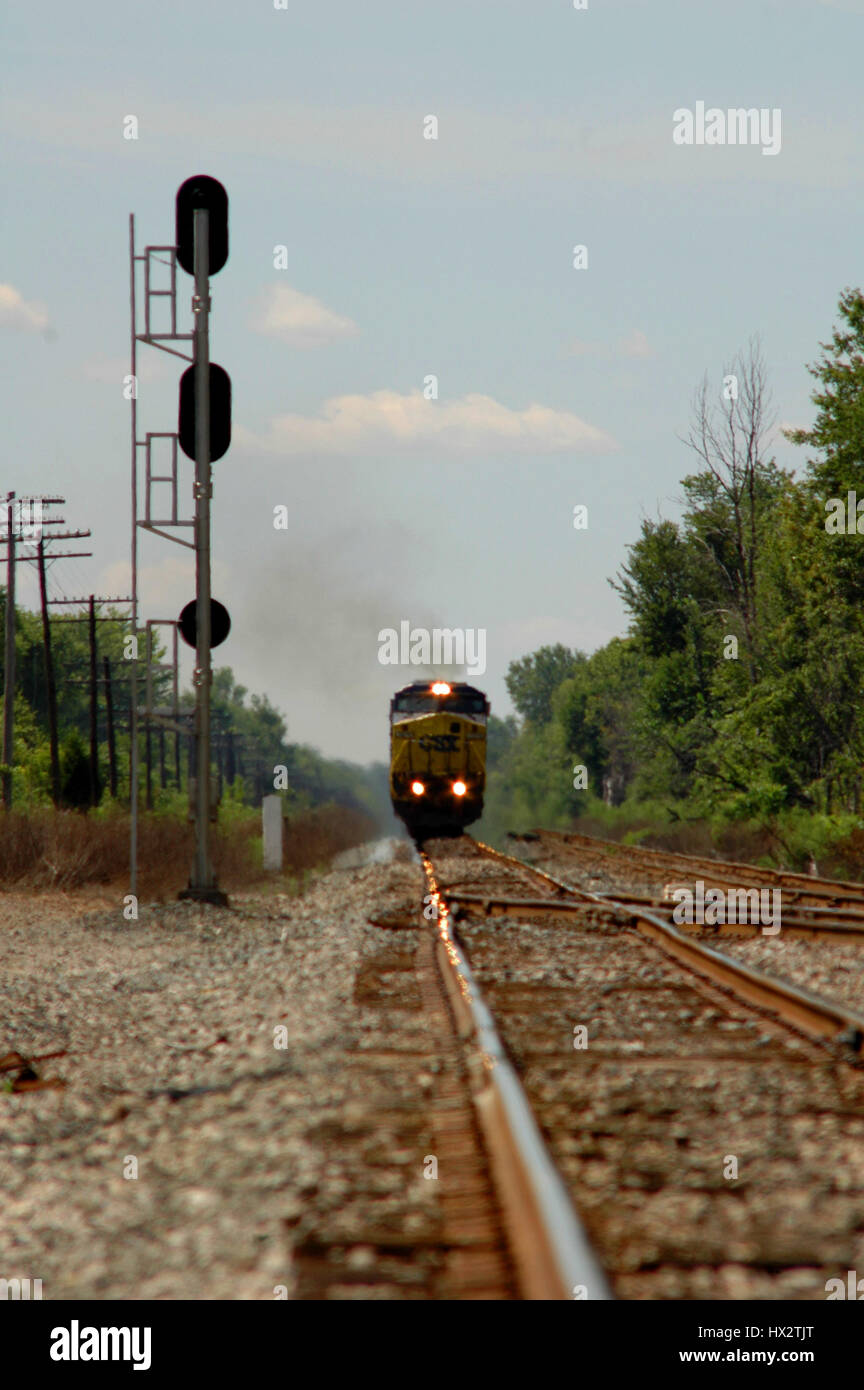train coming down rail in distance light on vertical Stock Photo - Alamy