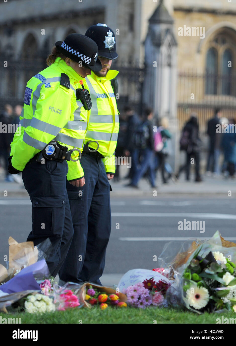 Police officers look at flowers on Parliament Square outside the Houses ...