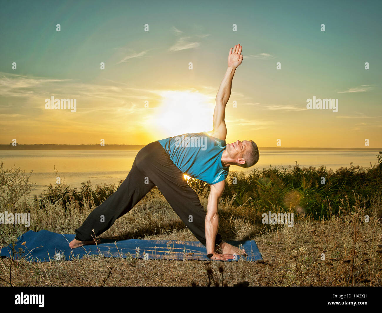smiling man making yoga exercises outdoors Stock Photo - Alamy