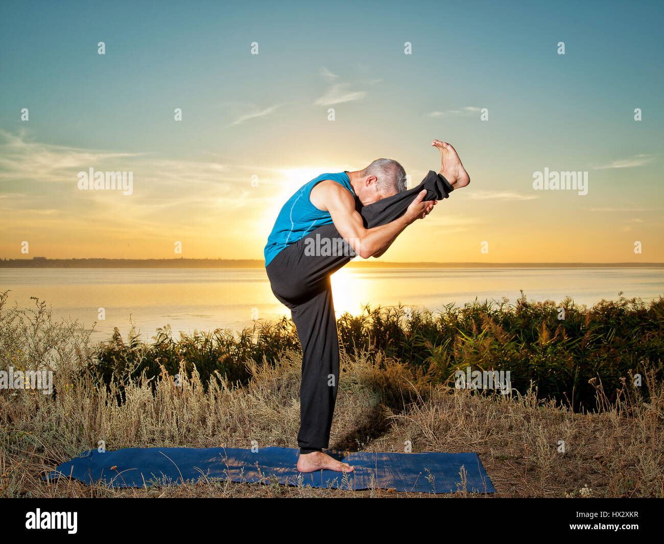 smiling man making yoga exercises outdoors Stock Photo - Alamy