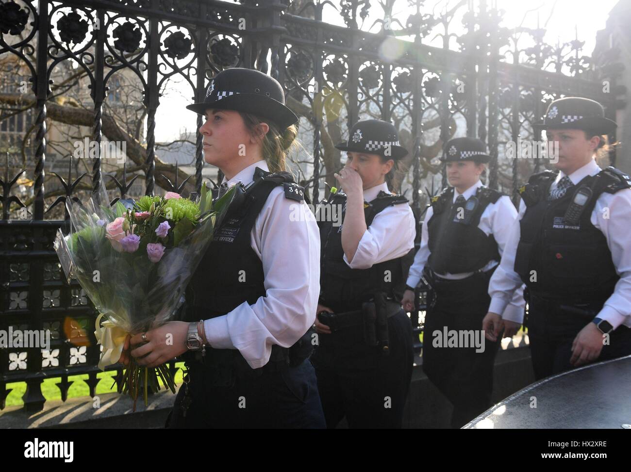 Police officers leave flowers outside the Houses of Parliament in ...