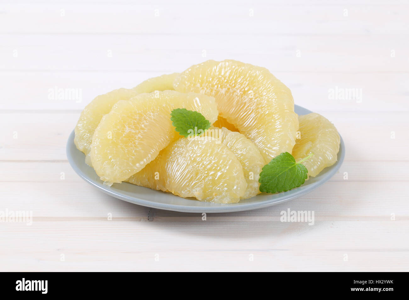 plate of peeled and sliced pomelo on white background Stock Photo - Alamy
