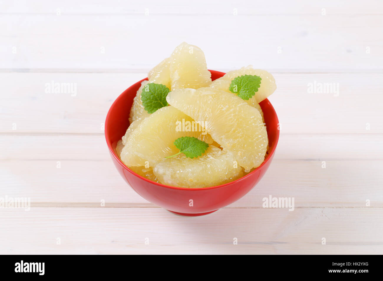 bowl of peeled and sliced pomelo on white background Stock Photo - Alamy