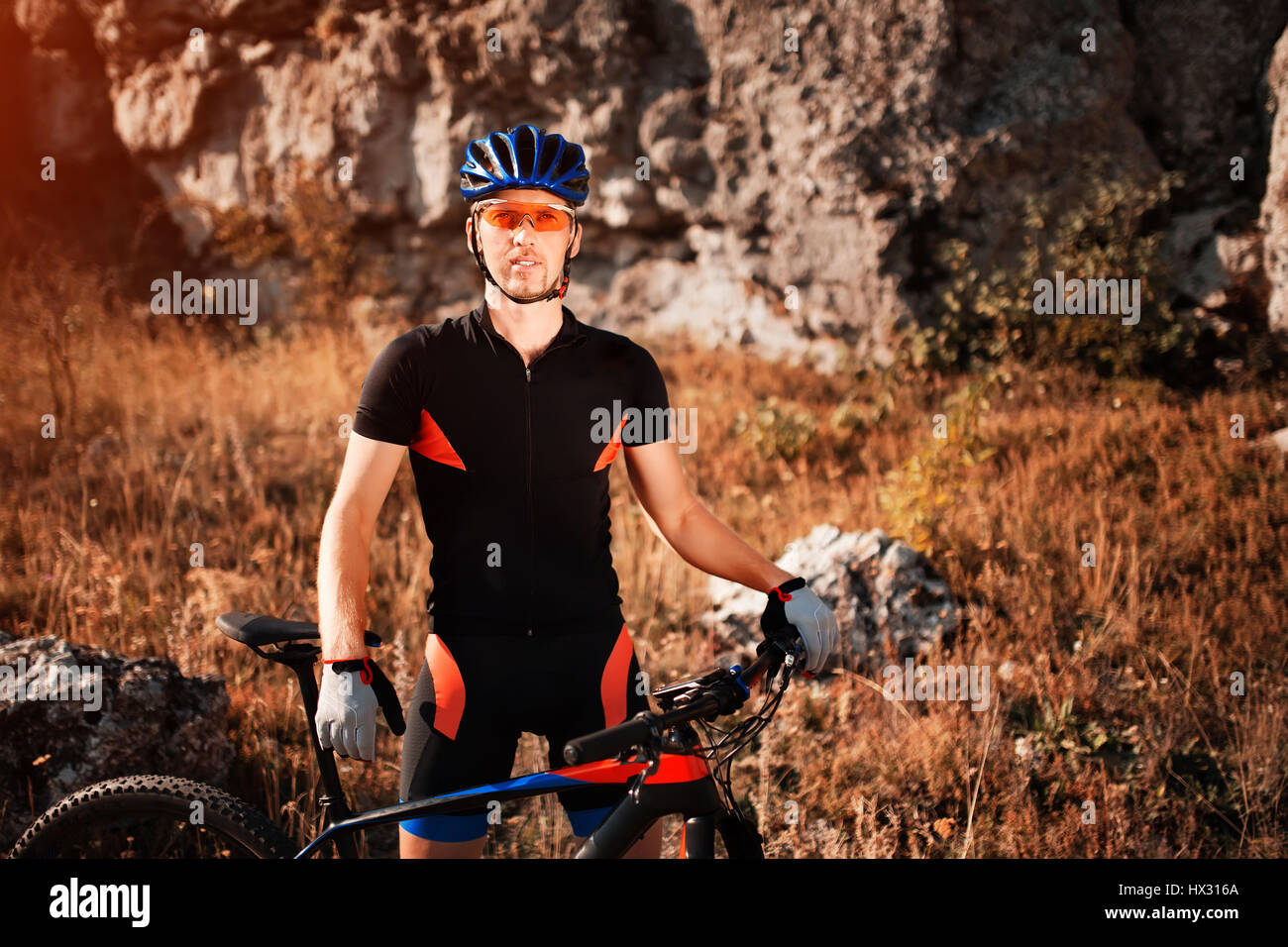 Portrait of a cyclist in helmet and sunglasses on a mountain bike ...