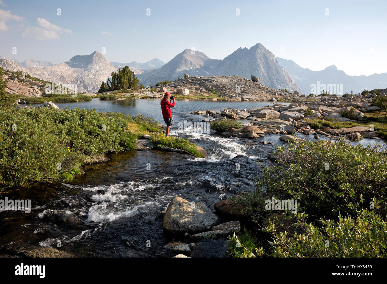 CA03105-00...CALIFORNIA - Hiker photographing a small pond on Darwin ...