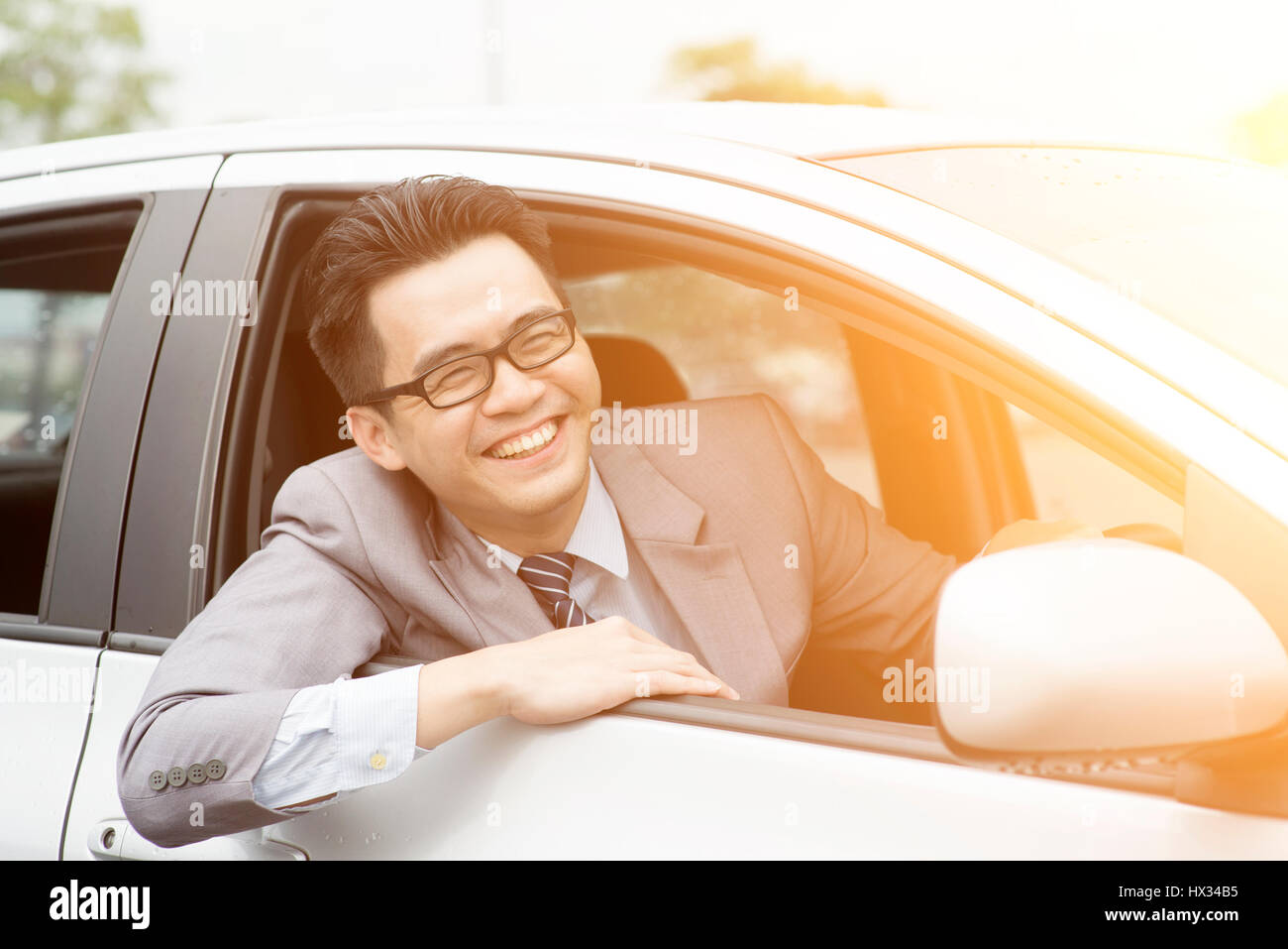 Happy Asian driver sitting in his car and smiling Stock Photo - Alamy