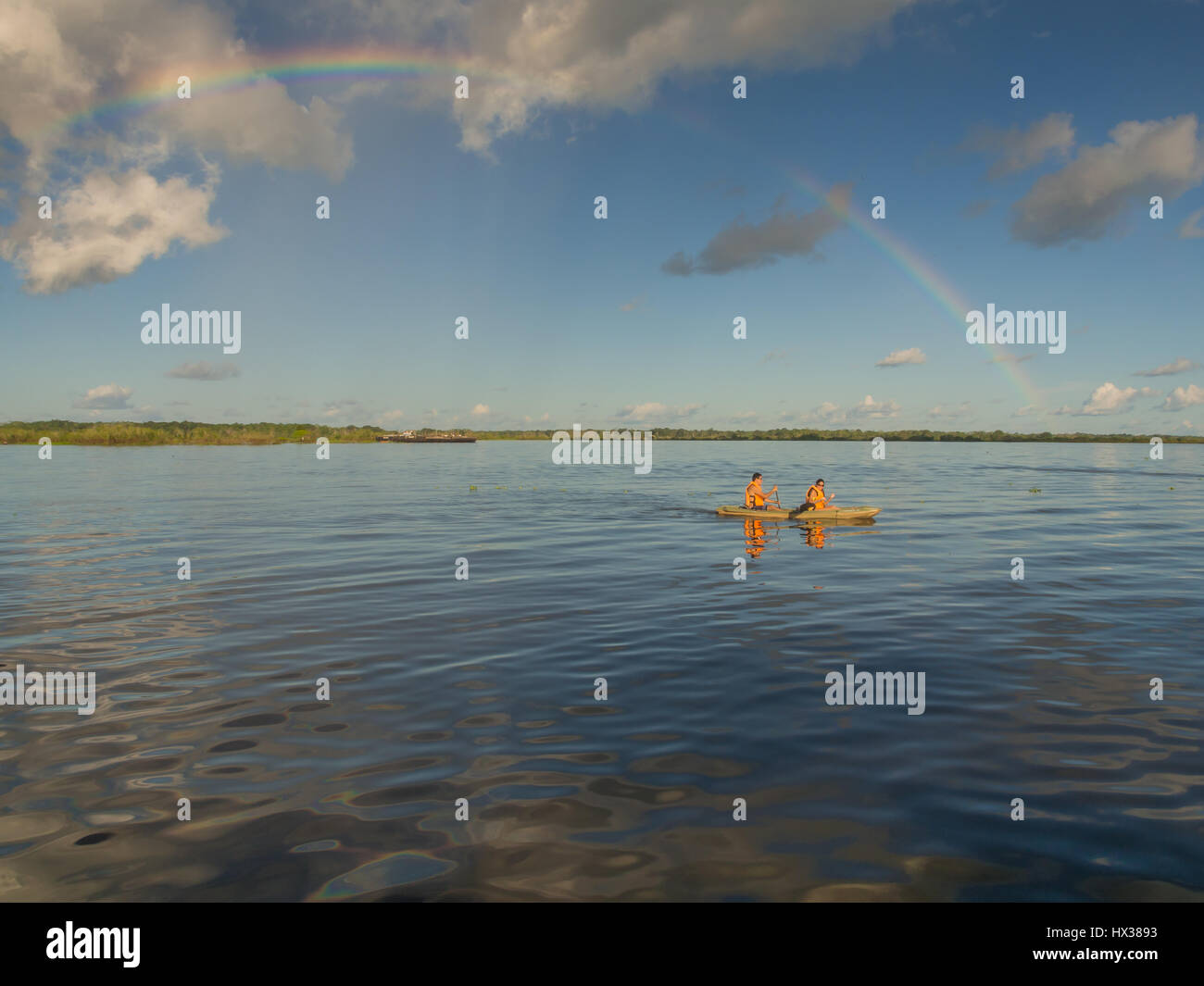 Iquitos, Peru- May 16, 2016: Rainbow over Amazon river and kayak with ...