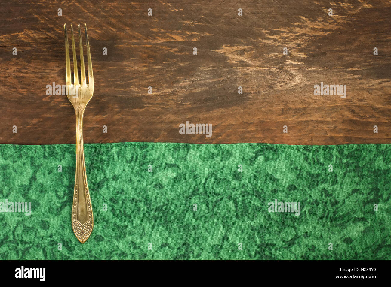 An overhead photo of a vintage fork on a dark wooden background texture ...