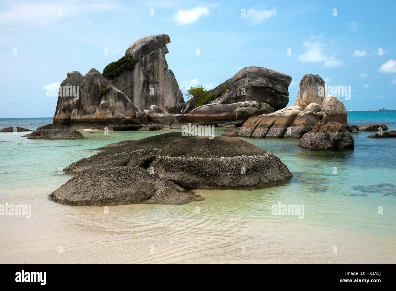 Natural rock formation in the sea and on a white sand beach in Belitung ...
