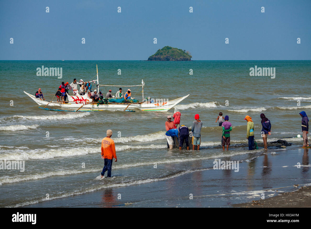 Members of a Filipino fishing village prepare to lay out their seine ...