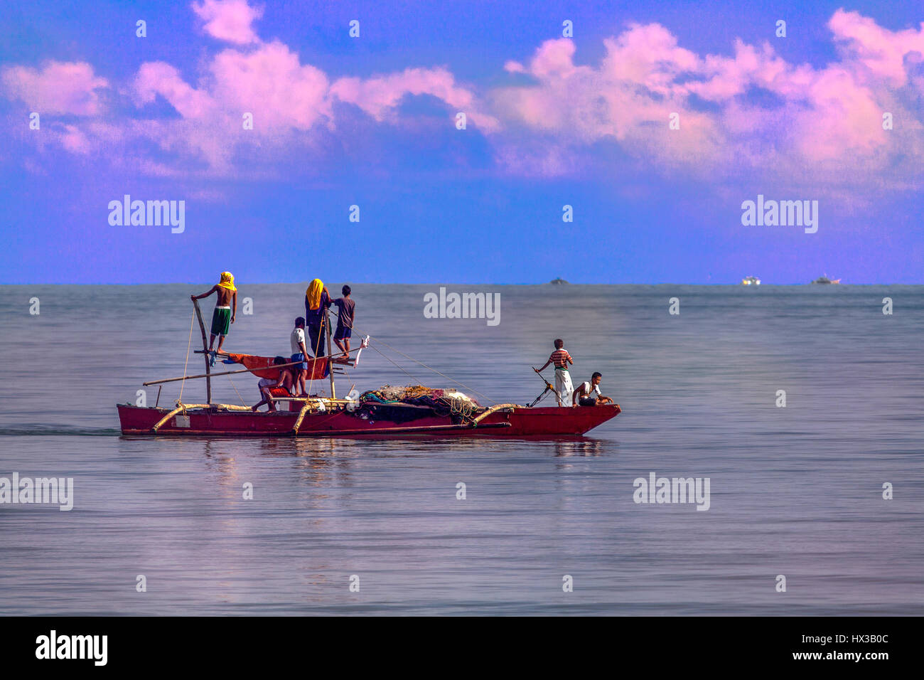 The Filipino crew of an outrigger fishing boat heads back to shore ...
