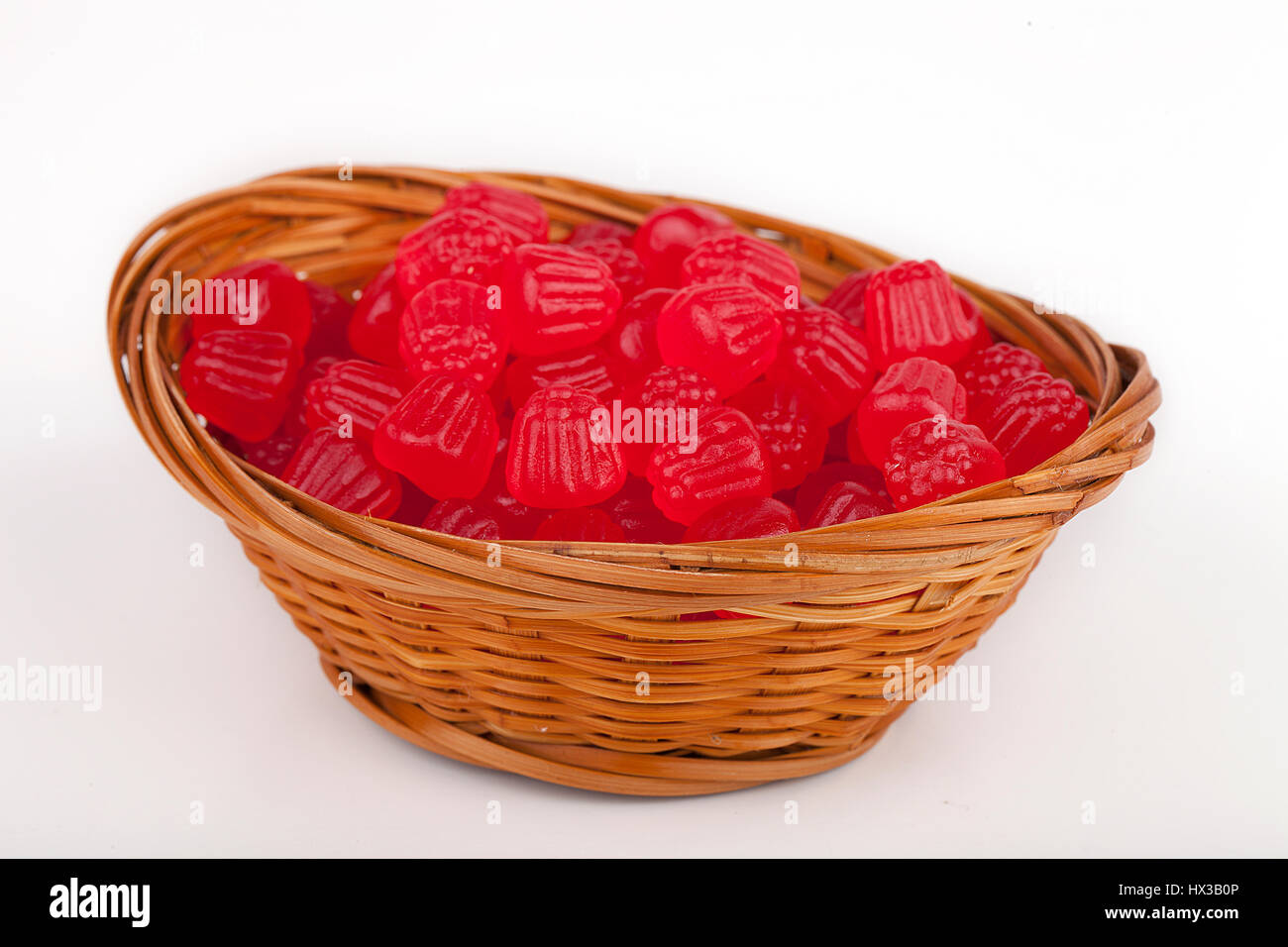 Wicker basket of raspberry jelly candies isolated on white background ...