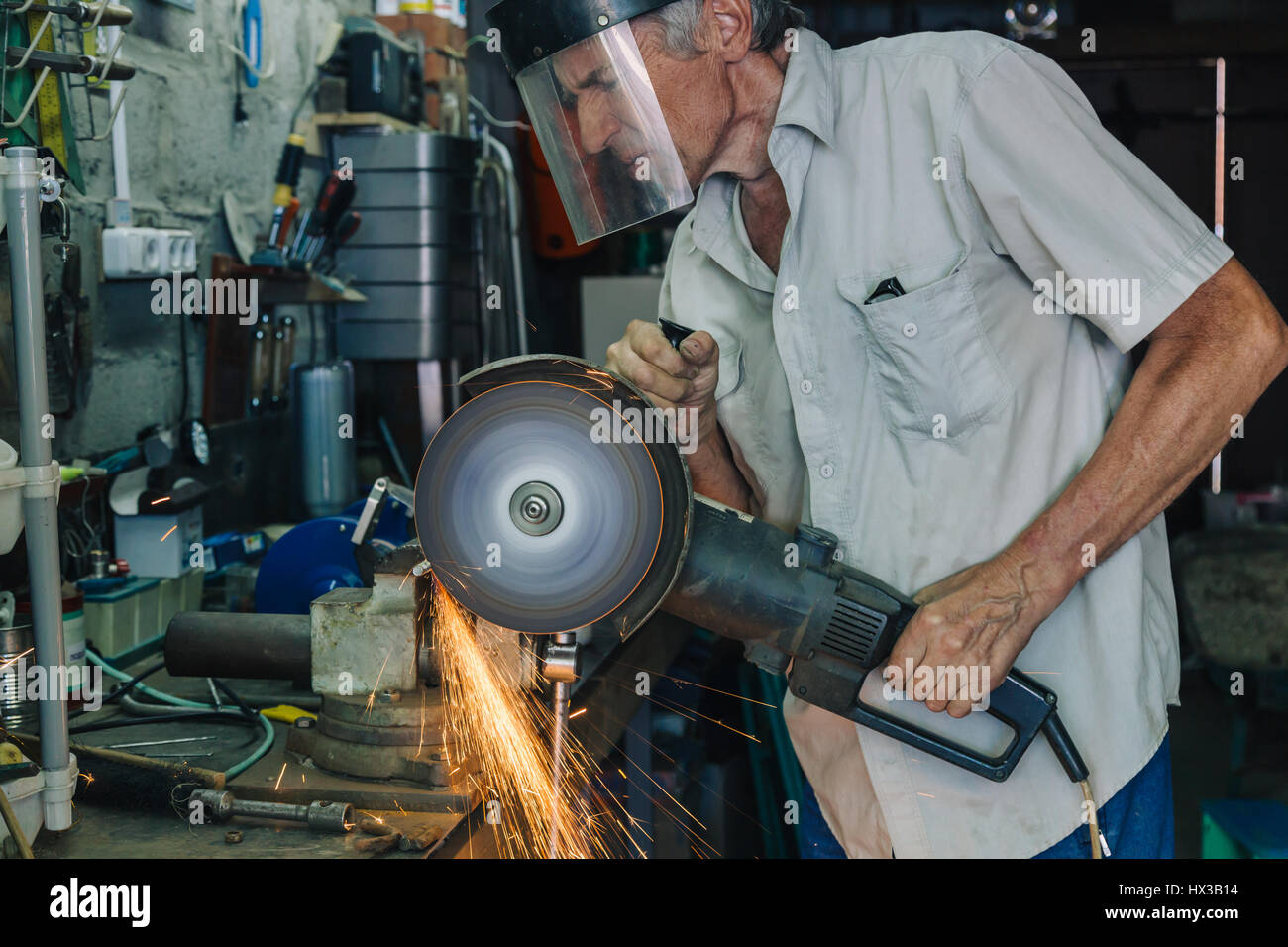 Senior man working with angle grinder Stock Photo - Alamy