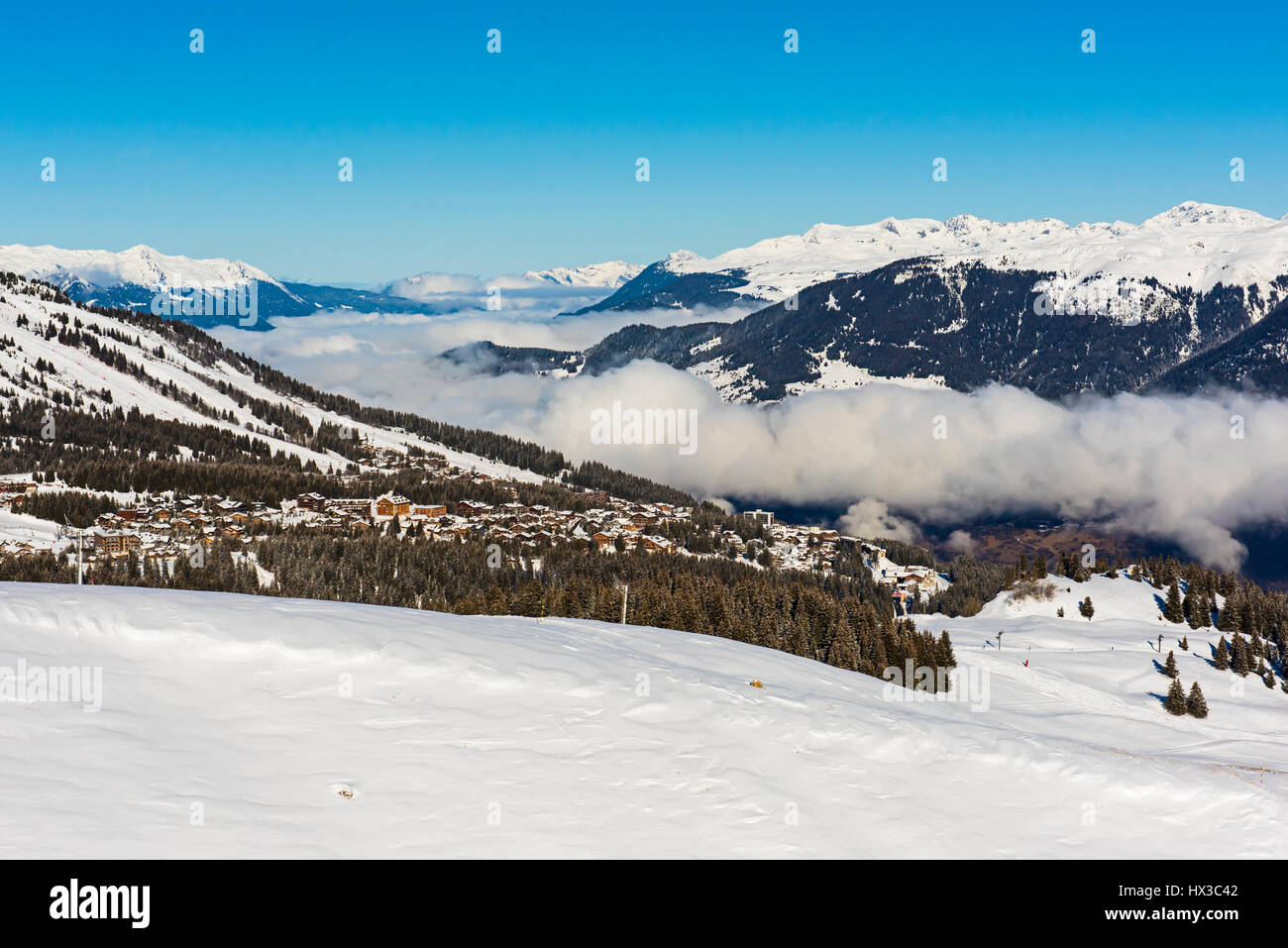 Panoramic view down snow covered valley in alpine mountain range with ...