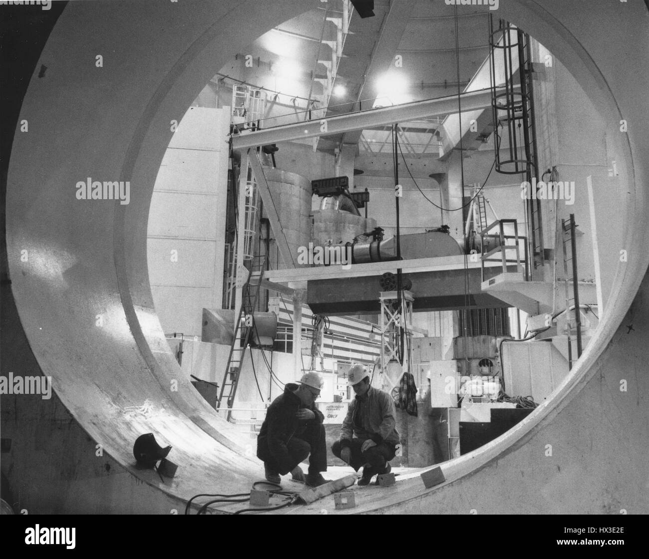 Workmen prepare to close a construction hatch in the five-foot thich ...