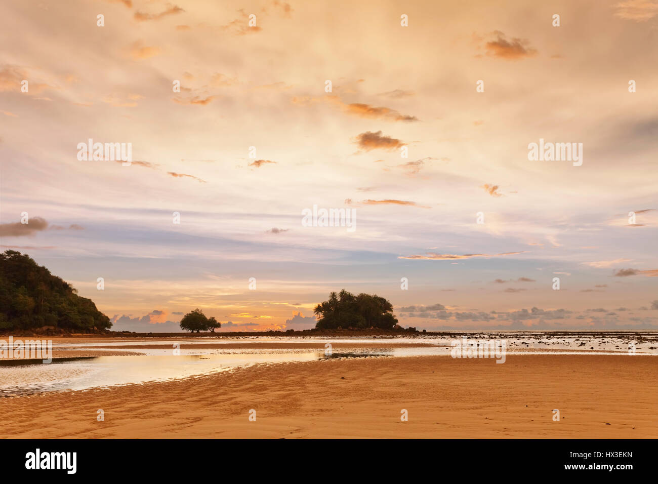 Tropical beach in ebb time on sunset background Stock Photo - Alamy