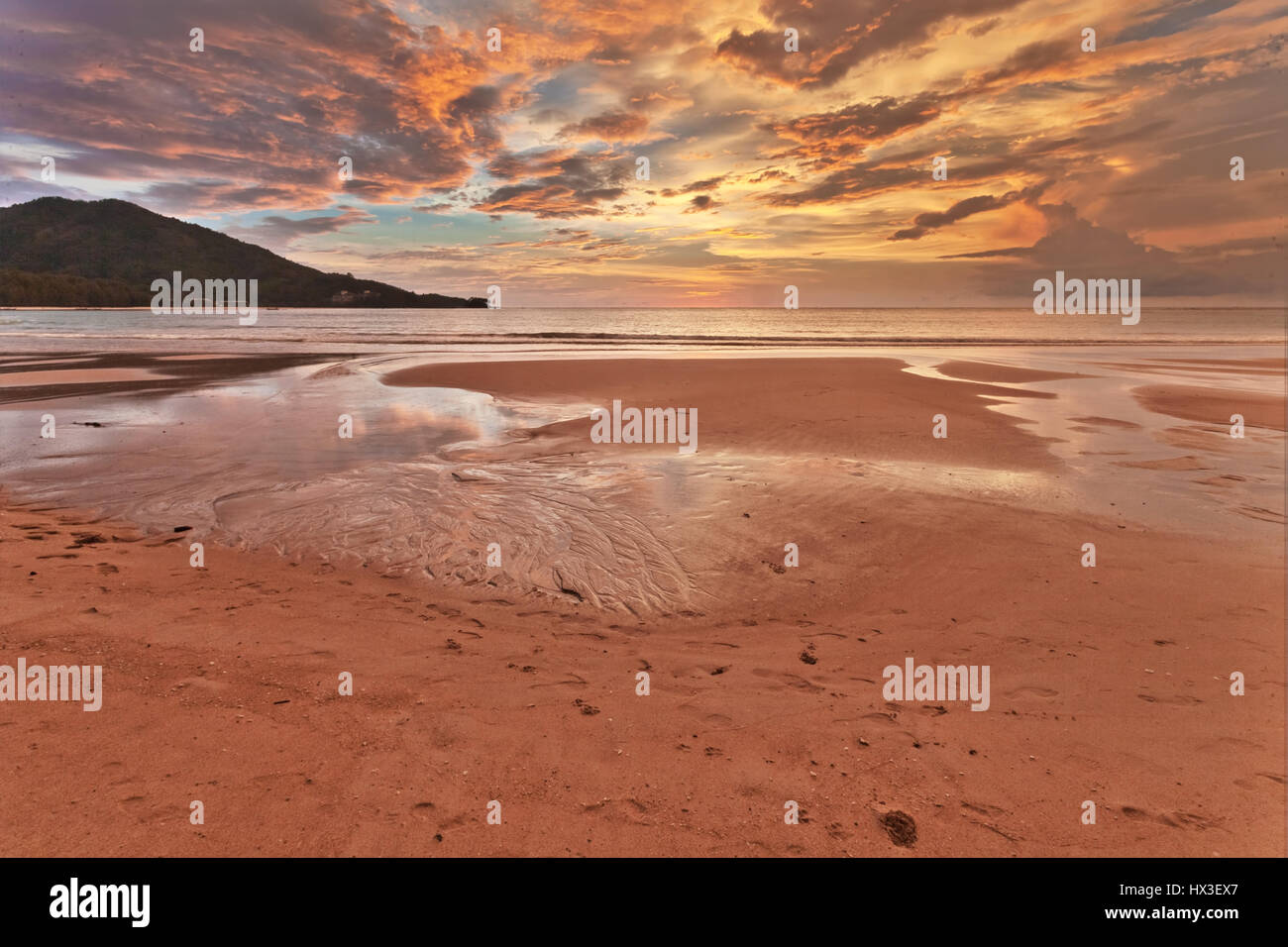 Tropical beach in ebb time on sunset background Stock Photo - Alamy