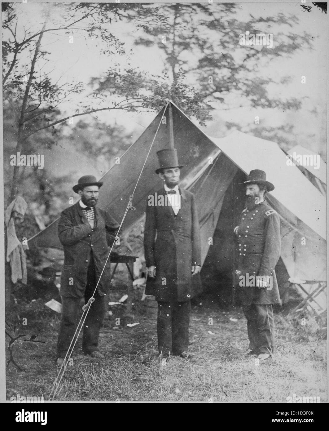 President Abraham Lincoln, flanked by civil war officials, standing ...