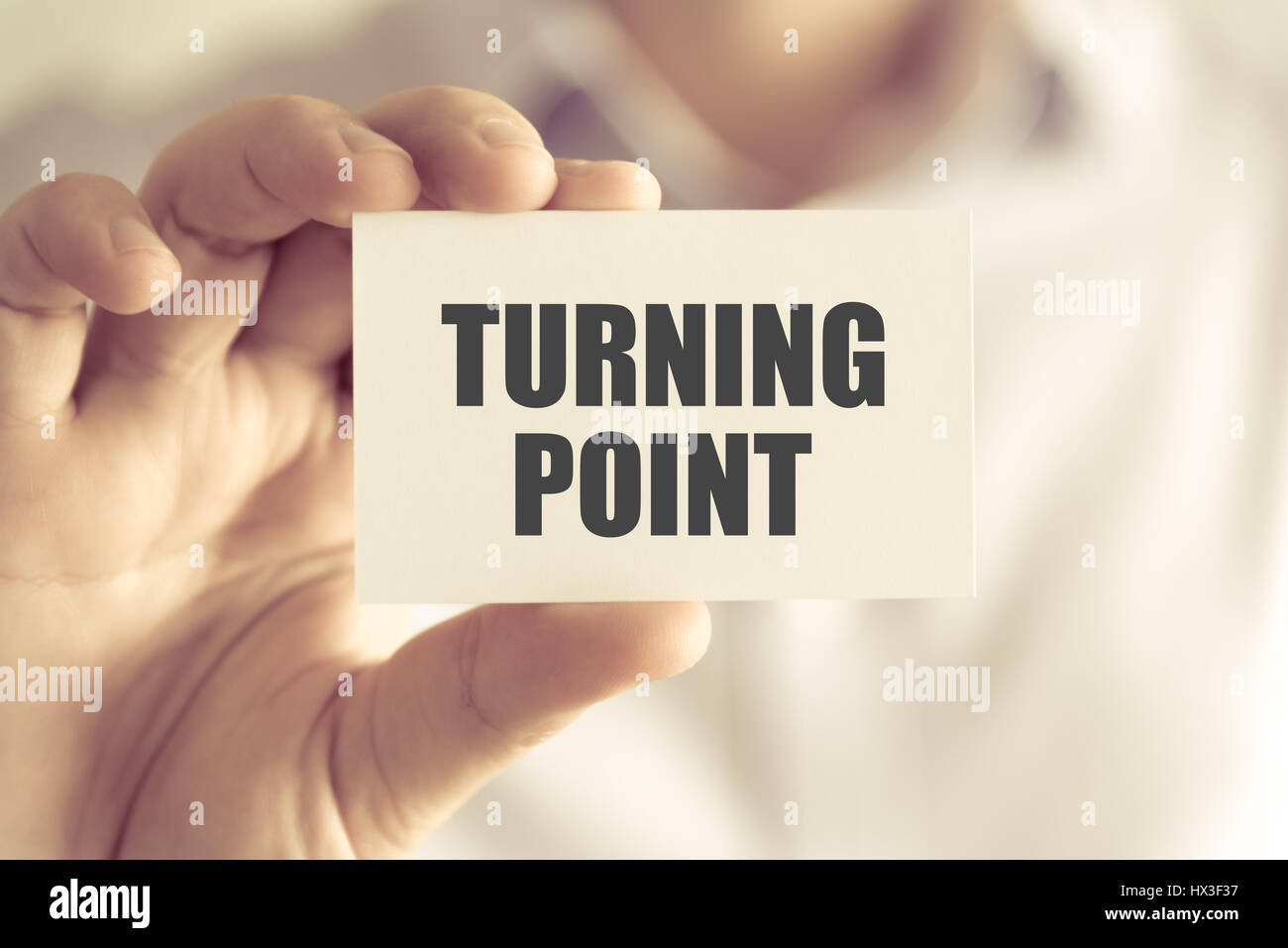 Closeup on businessman holding a card with text TURNING POINT, business ...