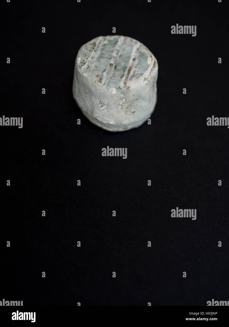 Small, dry, cylinder formed cheese isolated on black background Stock ...