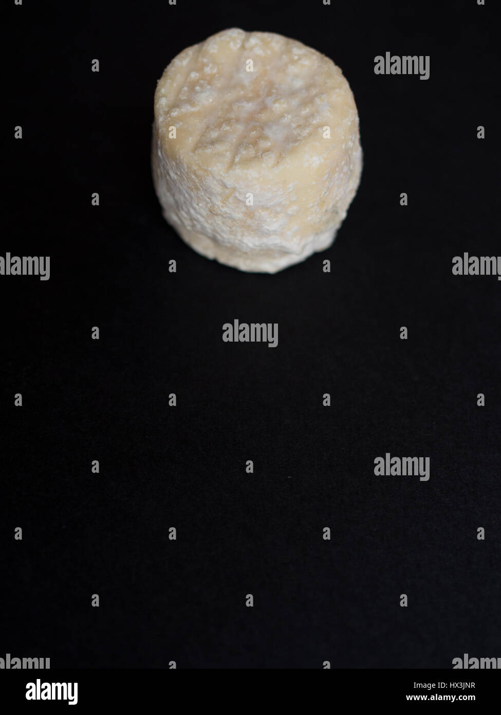 Small, dry, cylinder formed cheese isolated on black background Stock ...