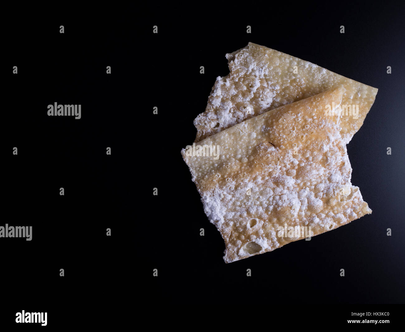 Oreillettes, bugnes or angel wings. Traditional french pastry sprinkled ...