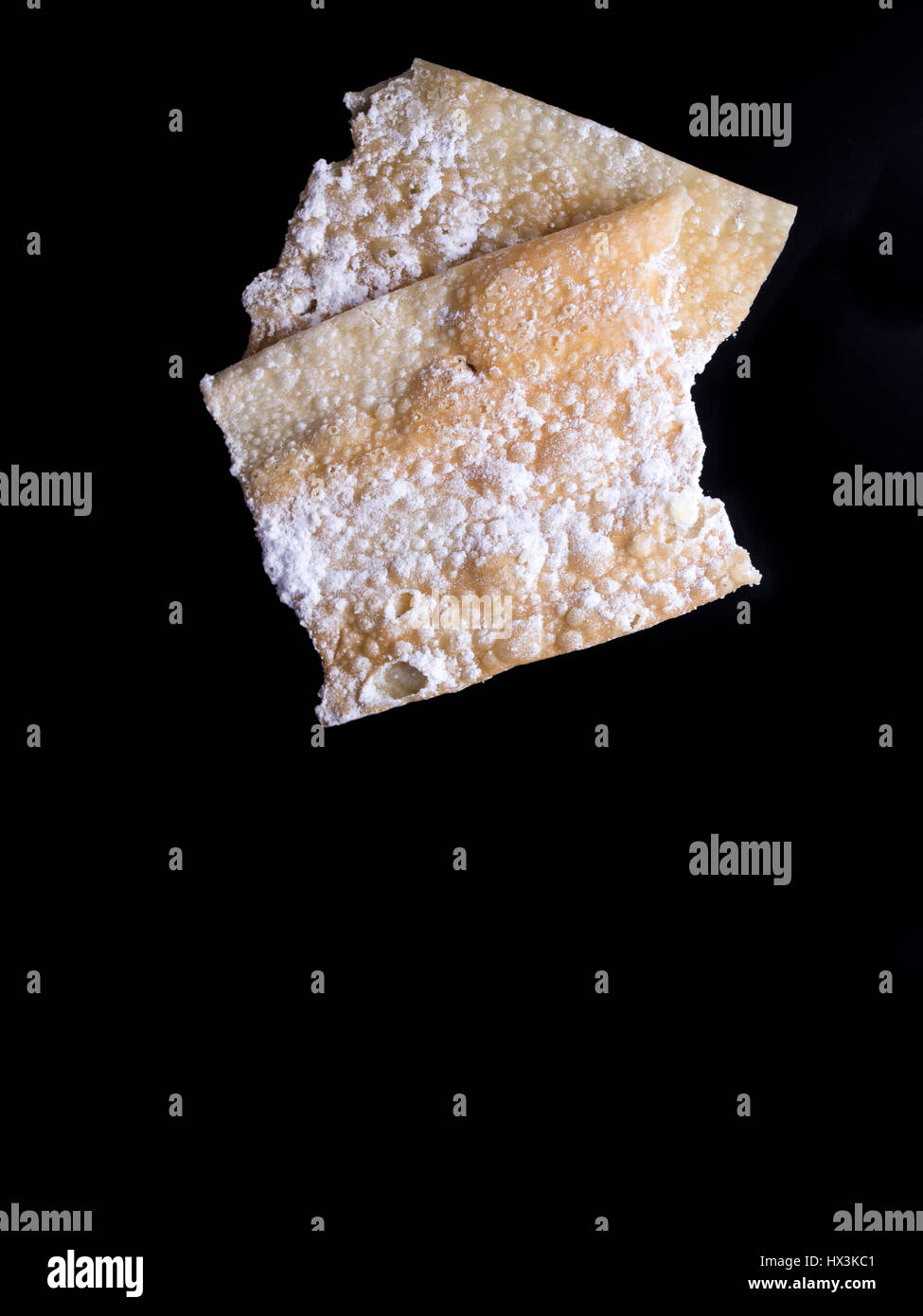 Oreillettes, bugnes or angel wings. Traditional french pastry sprinkled ...