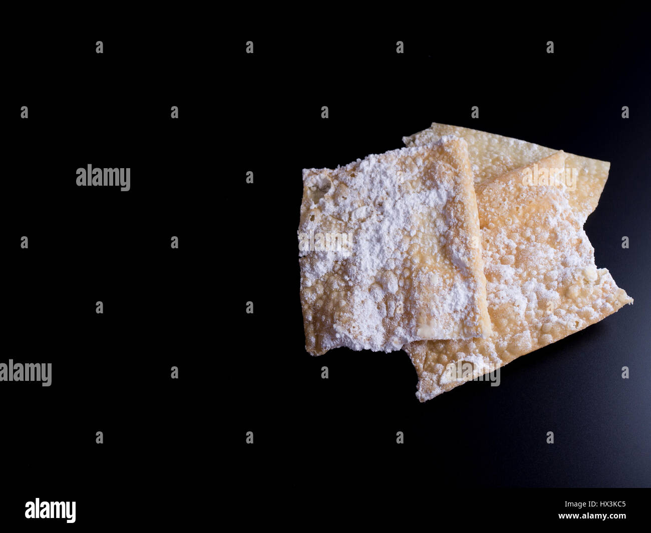 Oreillettes, bugnes or angel wings. Traditional french pastry sprinkled ...