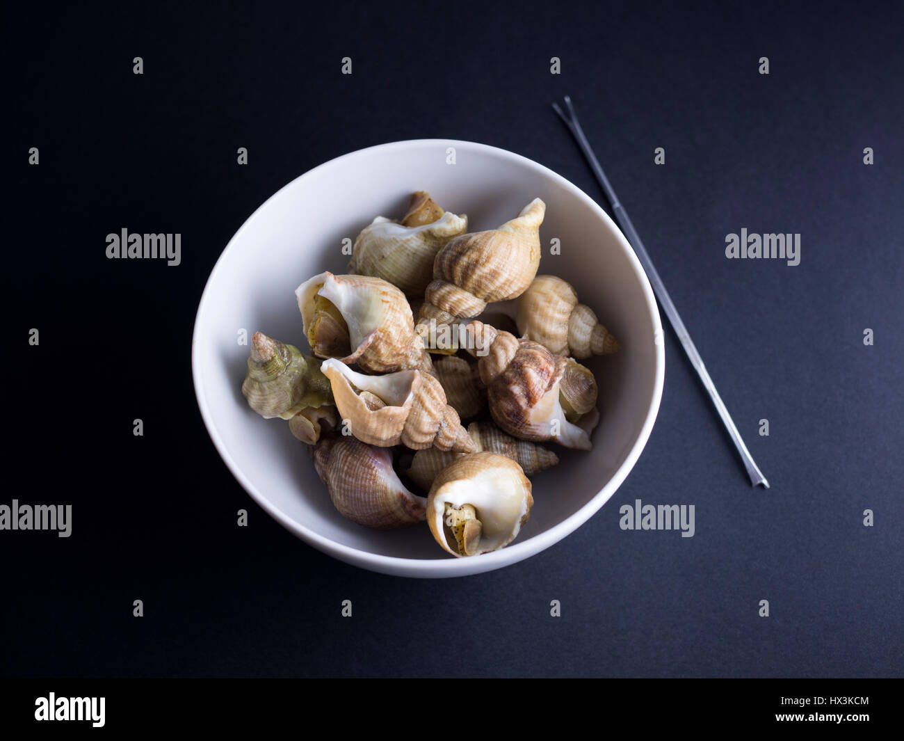 Whelks or sea snails in white bowl isolated on black background Stock ...