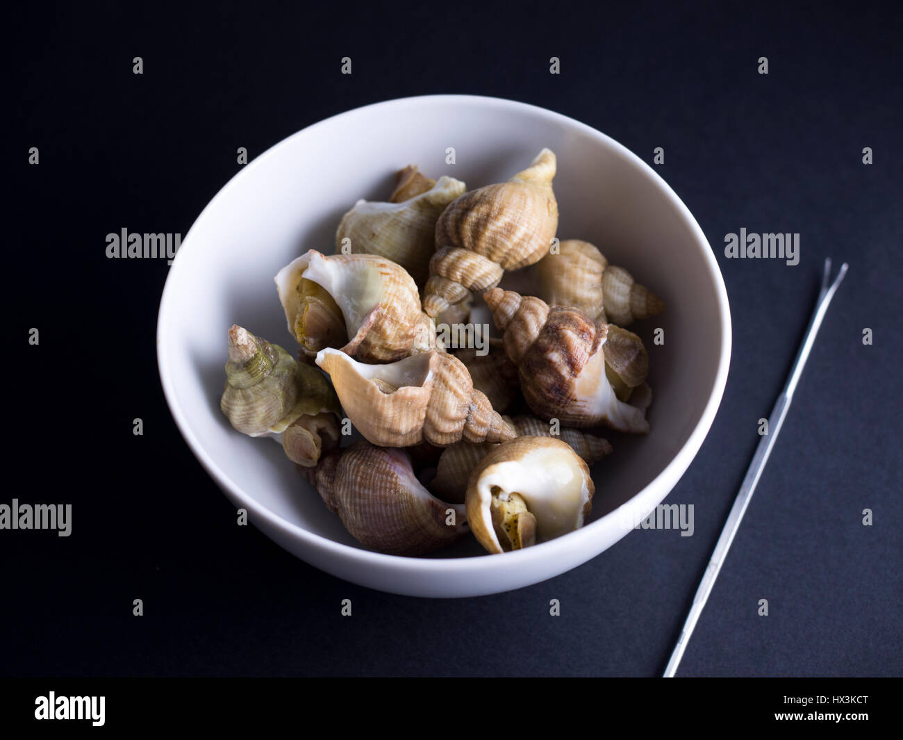 Whelks or sea snails in white bowl isolated on black background Stock ...