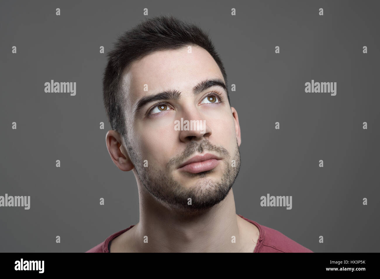 Close up of young handsome man face looking up thinking. Atmospheric ...