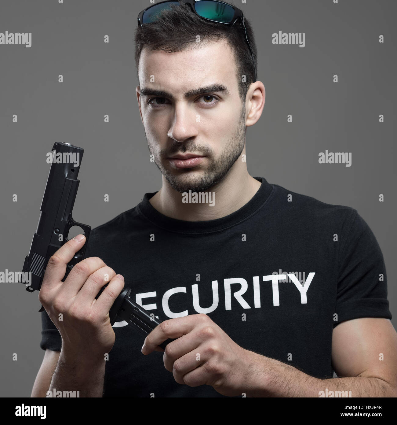 Tough dangerous security officer reloading handgun cartridge ...