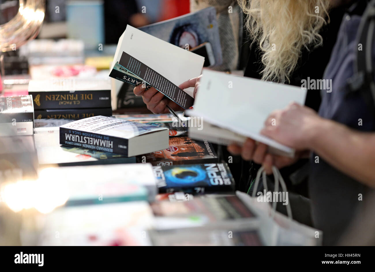 Visitors look at books at the stand of Random House at the Leipzig Book ...