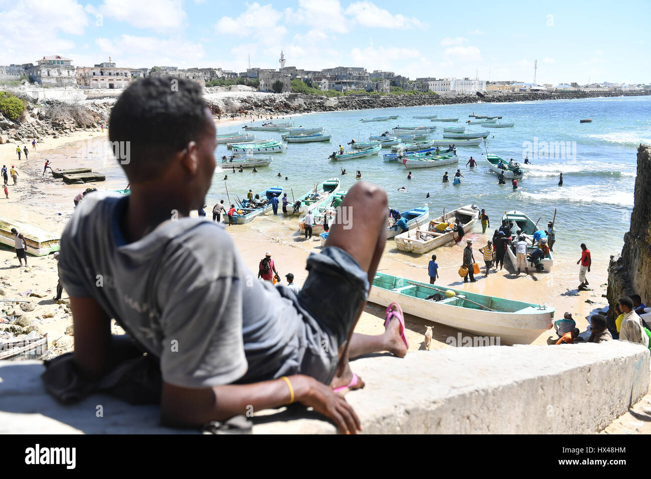 Mogadishu, Somalia. 23rd Mar, 2017. A man relaxes at a fishing harbor ...