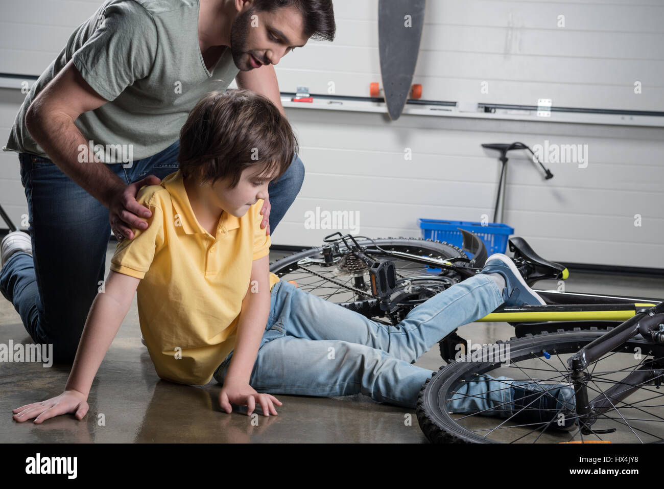 Father helping wounded son getting up from falling off bicycle Stock ...