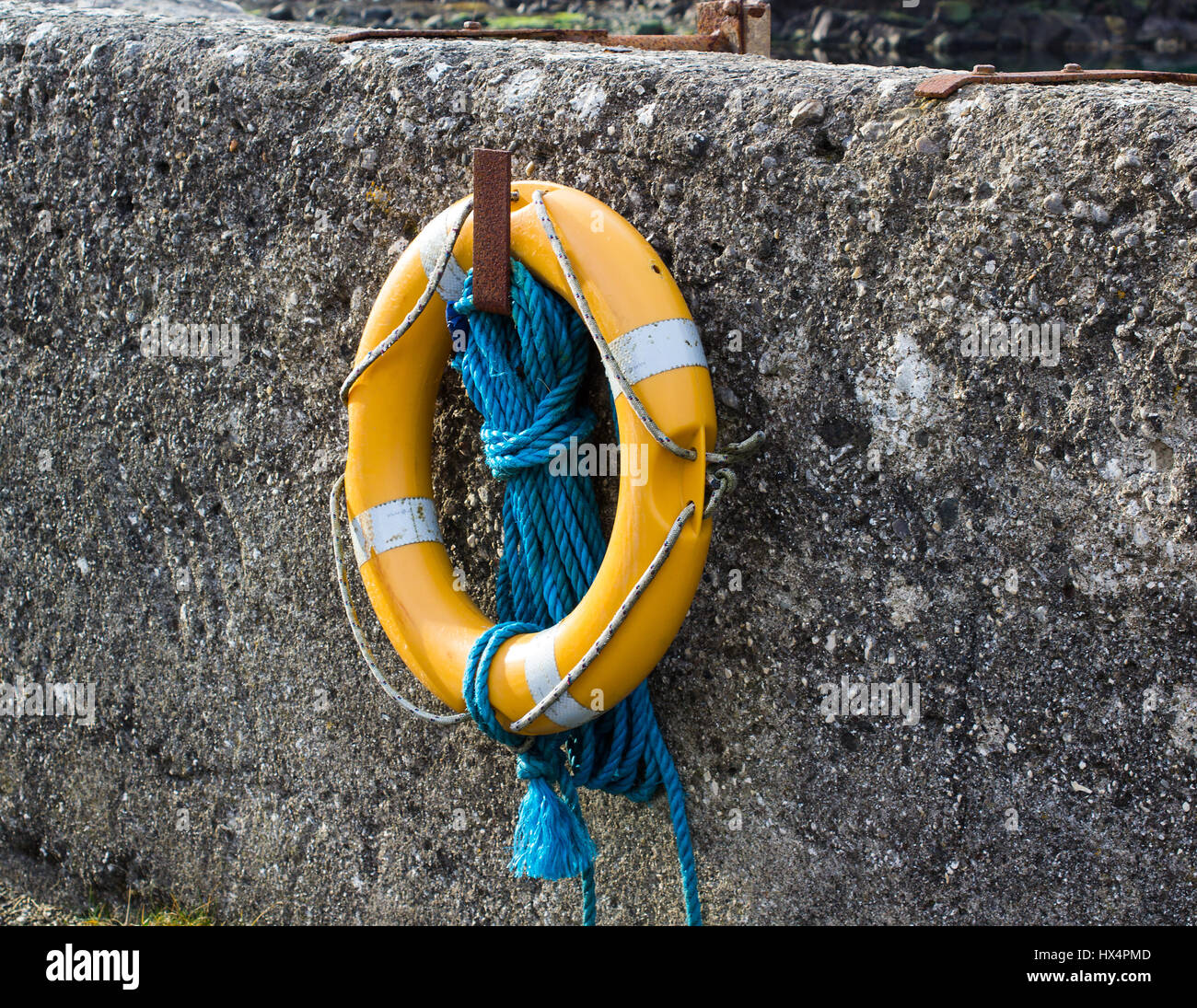 A luminous life saving ring and buoyancy hangs on the harbor wall in ...