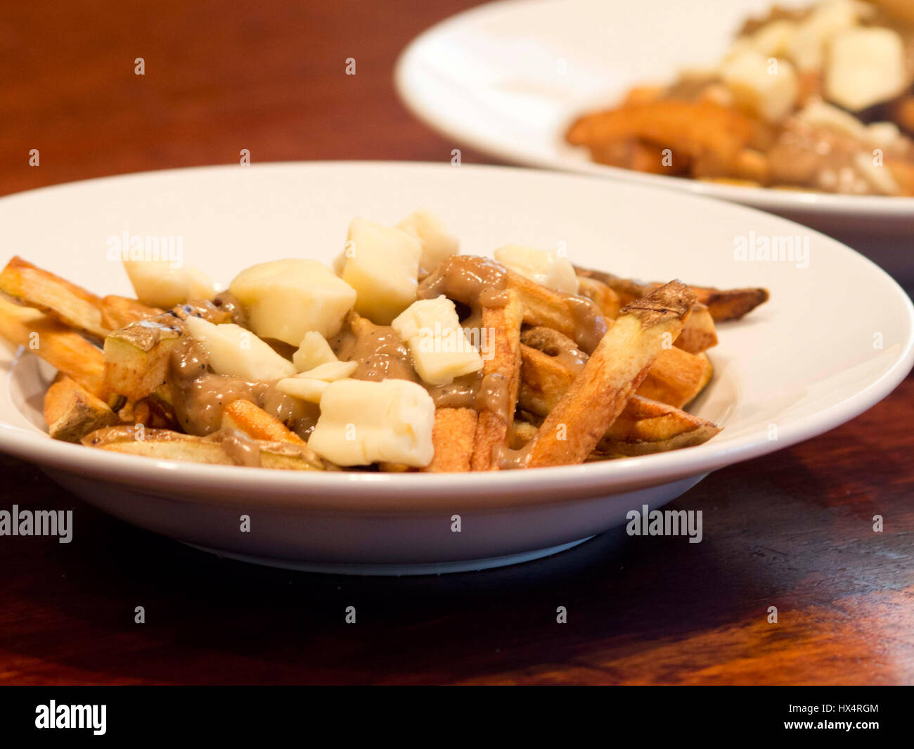 A bowl of homemade poutine, a Canadian dish made with fries, brown ...