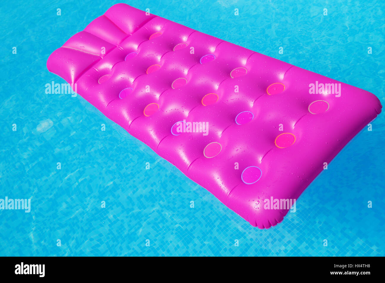 Pink air mattress on a swimming pool - holiday tropical background ...