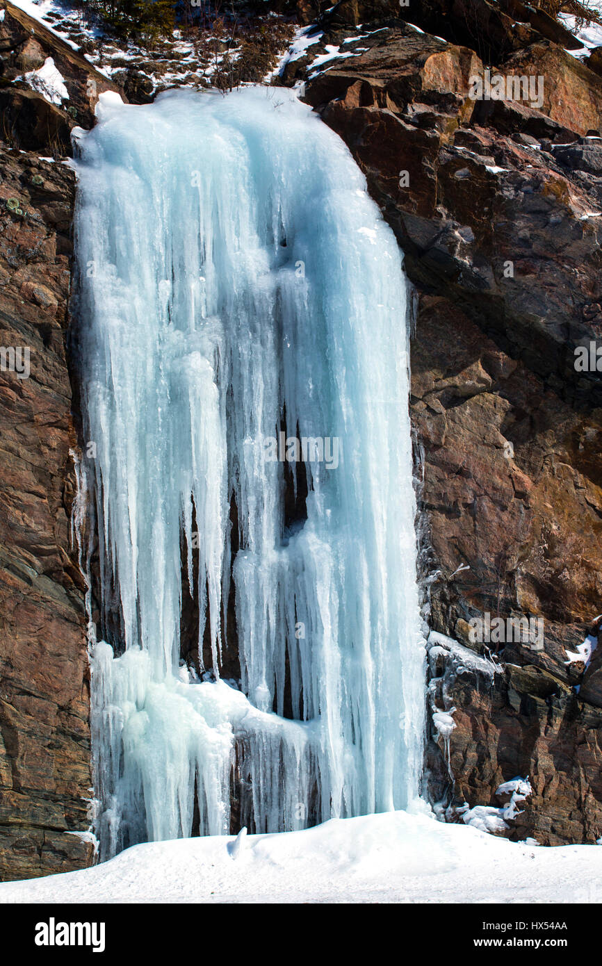 Natural stone rock face with ice from runoff Stock Photo - Alamy