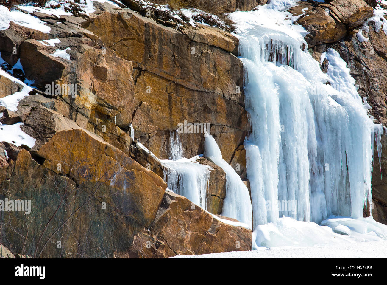 Natural stone rock face with ice from runoff Stock Photo - Alamy