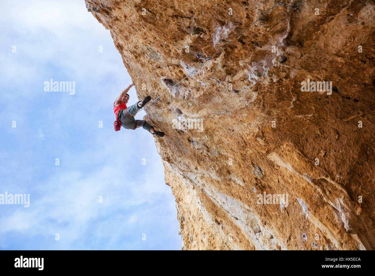 Smiling rock climber on overhanging cliff, view from beneath Stock ...